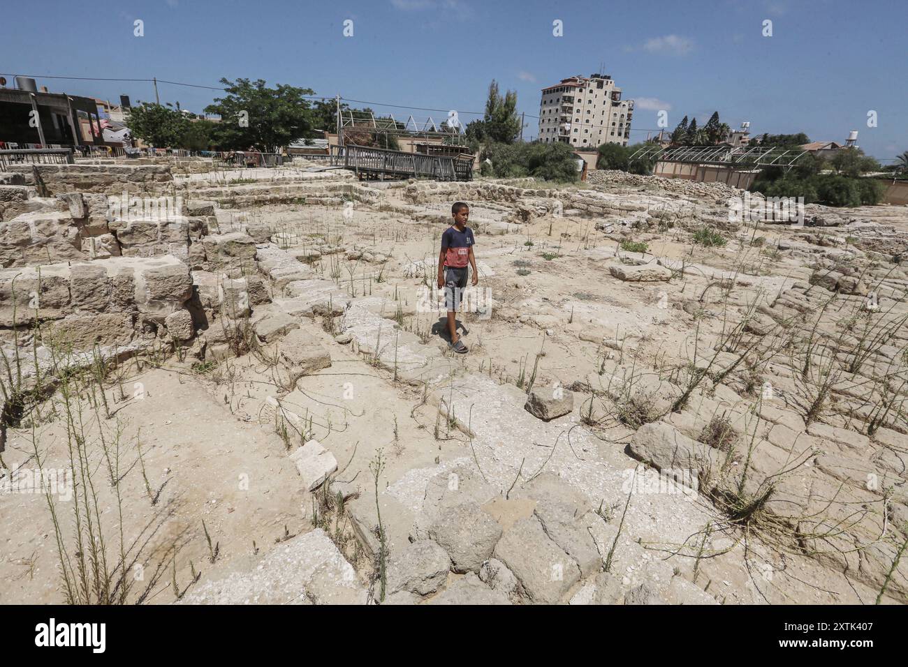 People stand on a platform overlooking ruins at the archaeological site ...