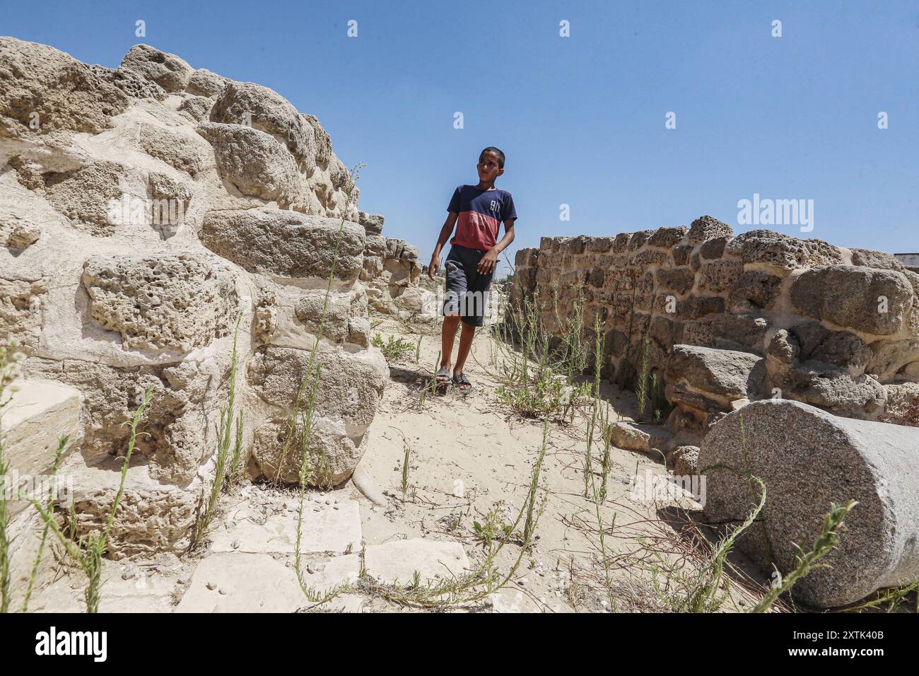 People stand on a platform overlooking ruins at the archaeological site ...