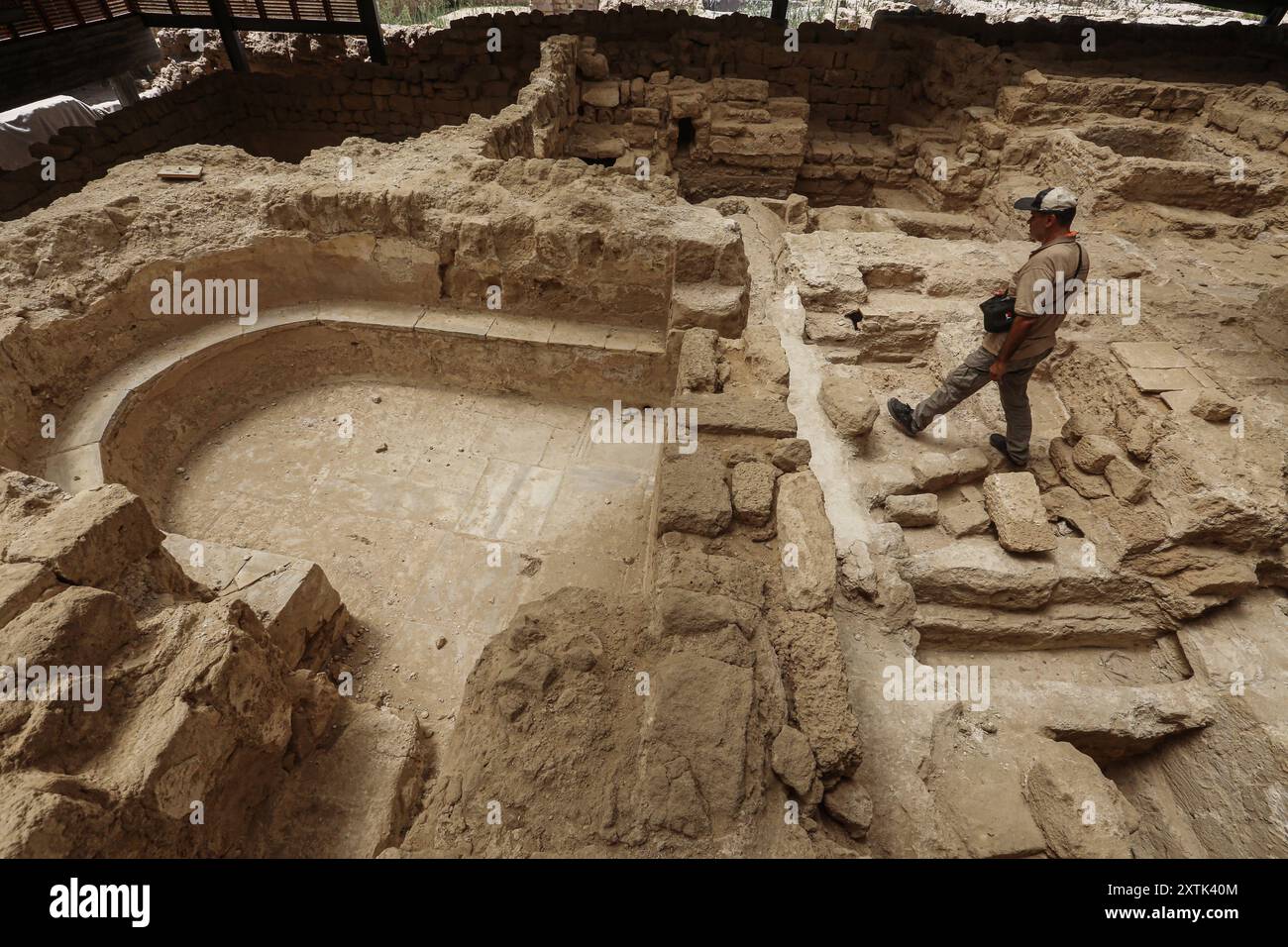 People stand on a platform overlooking ruins at the archaeological site ...