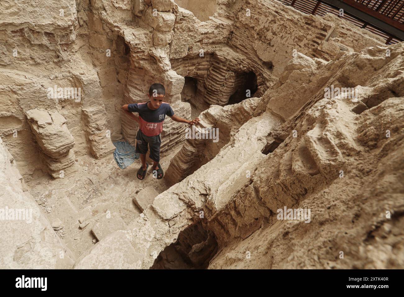 People stand on a platform overlooking ruins at the archaeological site ...