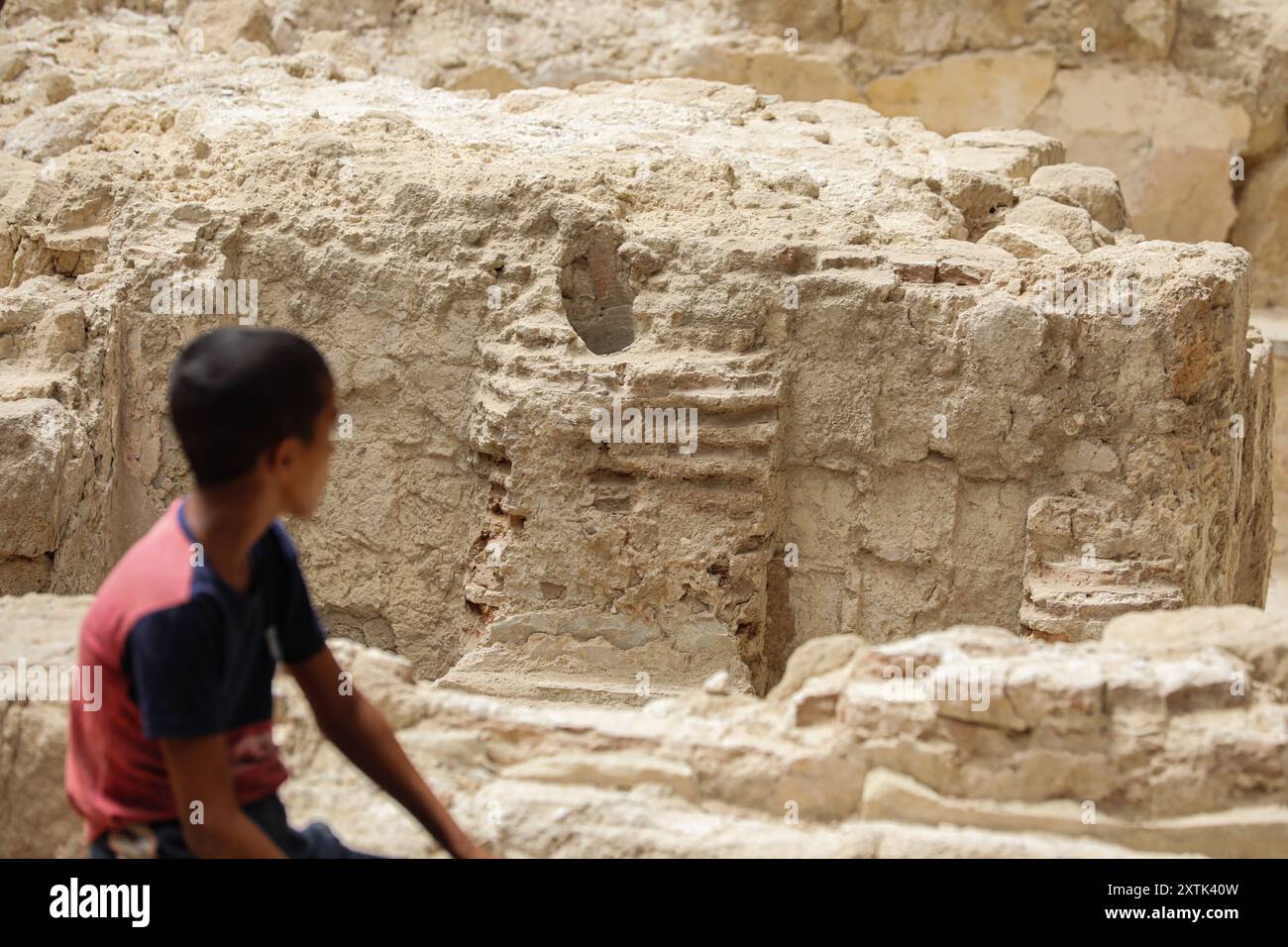 People stand on a platform overlooking ruins at the archaeological site ...