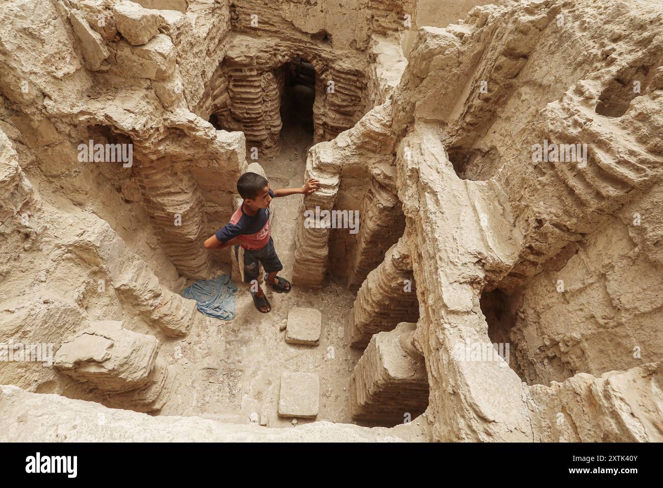 People stand on a platform overlooking ruins at the archaeological site ...