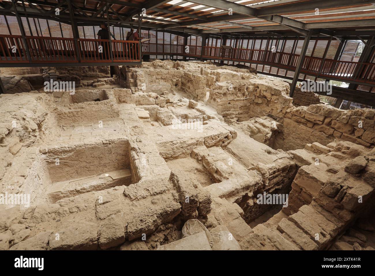 People stand on a platform overlooking ruins at the archaeological site ...