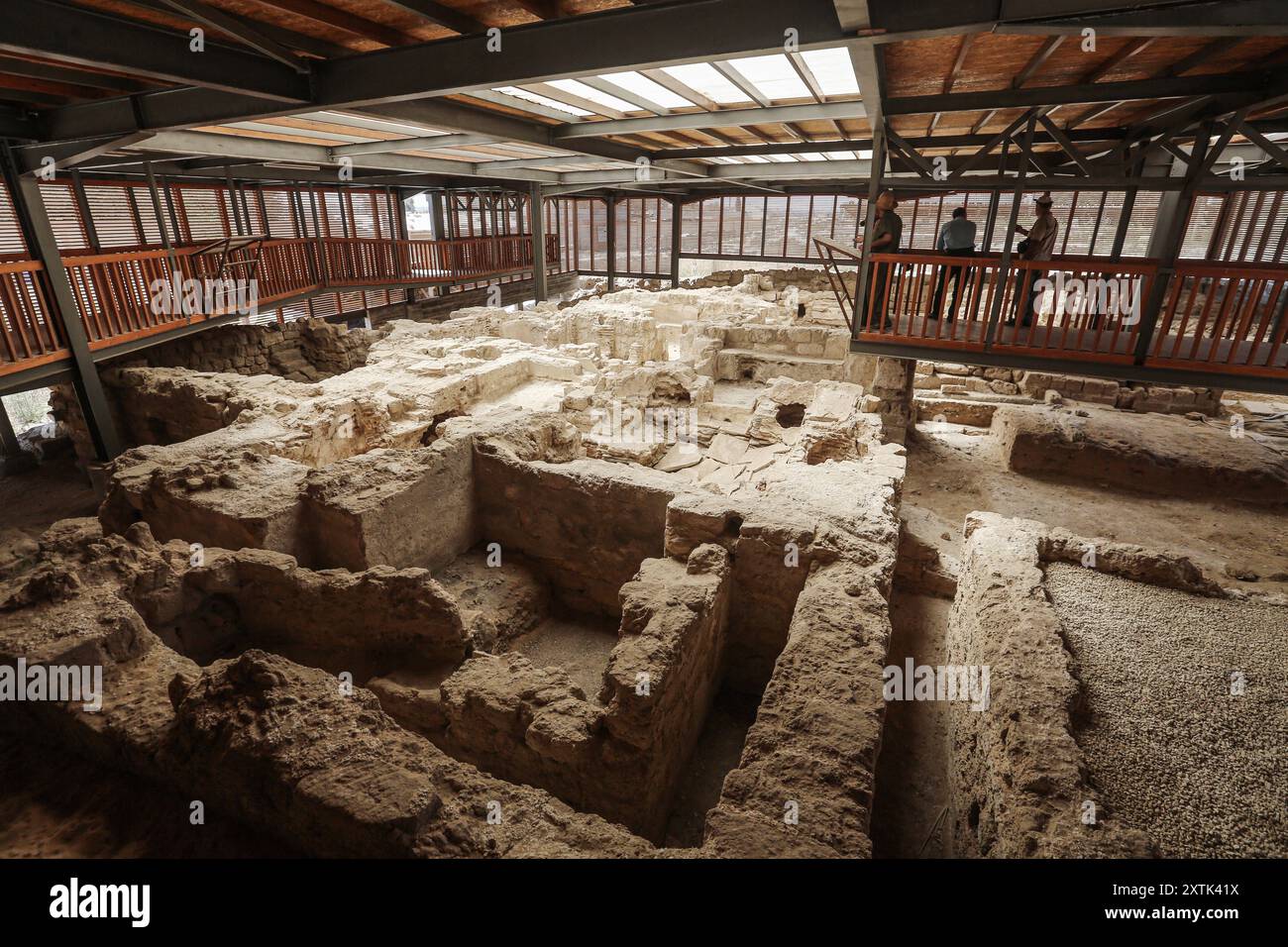 People stand on a platform overlooking ruins at the archaeological site ...