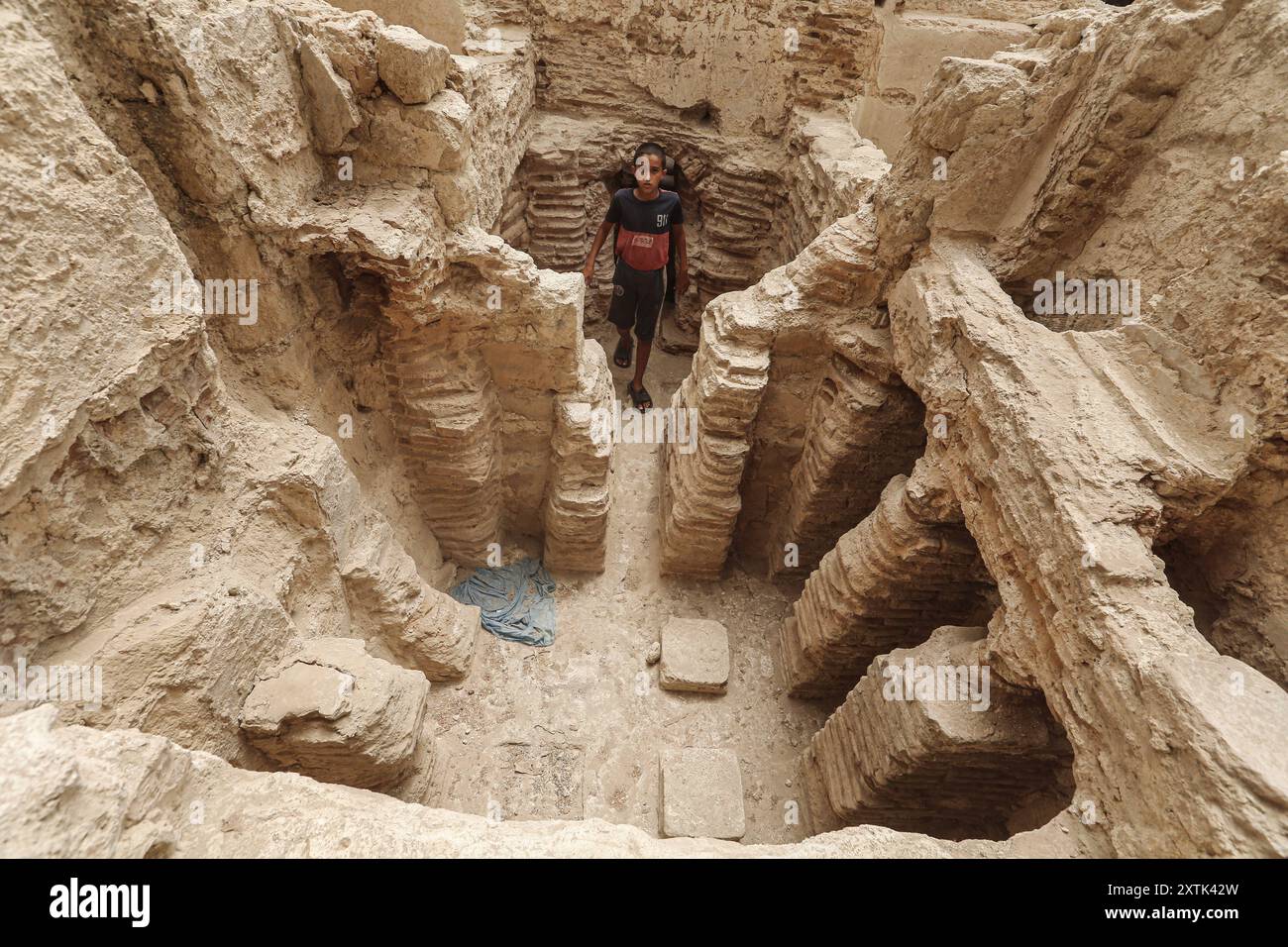 People stand on a platform overlooking ruins at the archaeological site ...