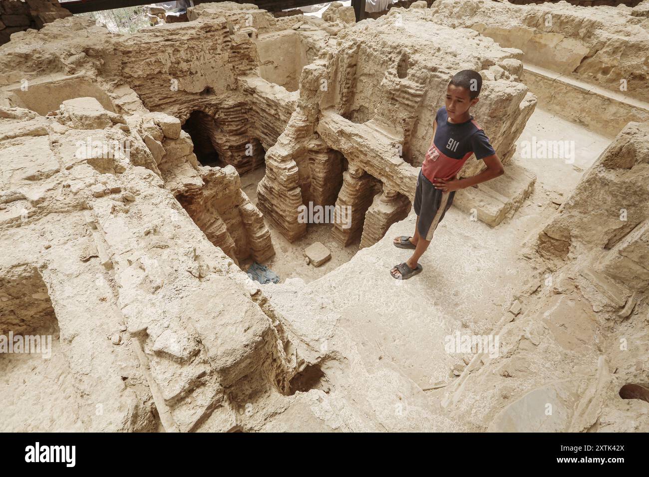 People stand on a platform overlooking ruins at the archaeological site ...