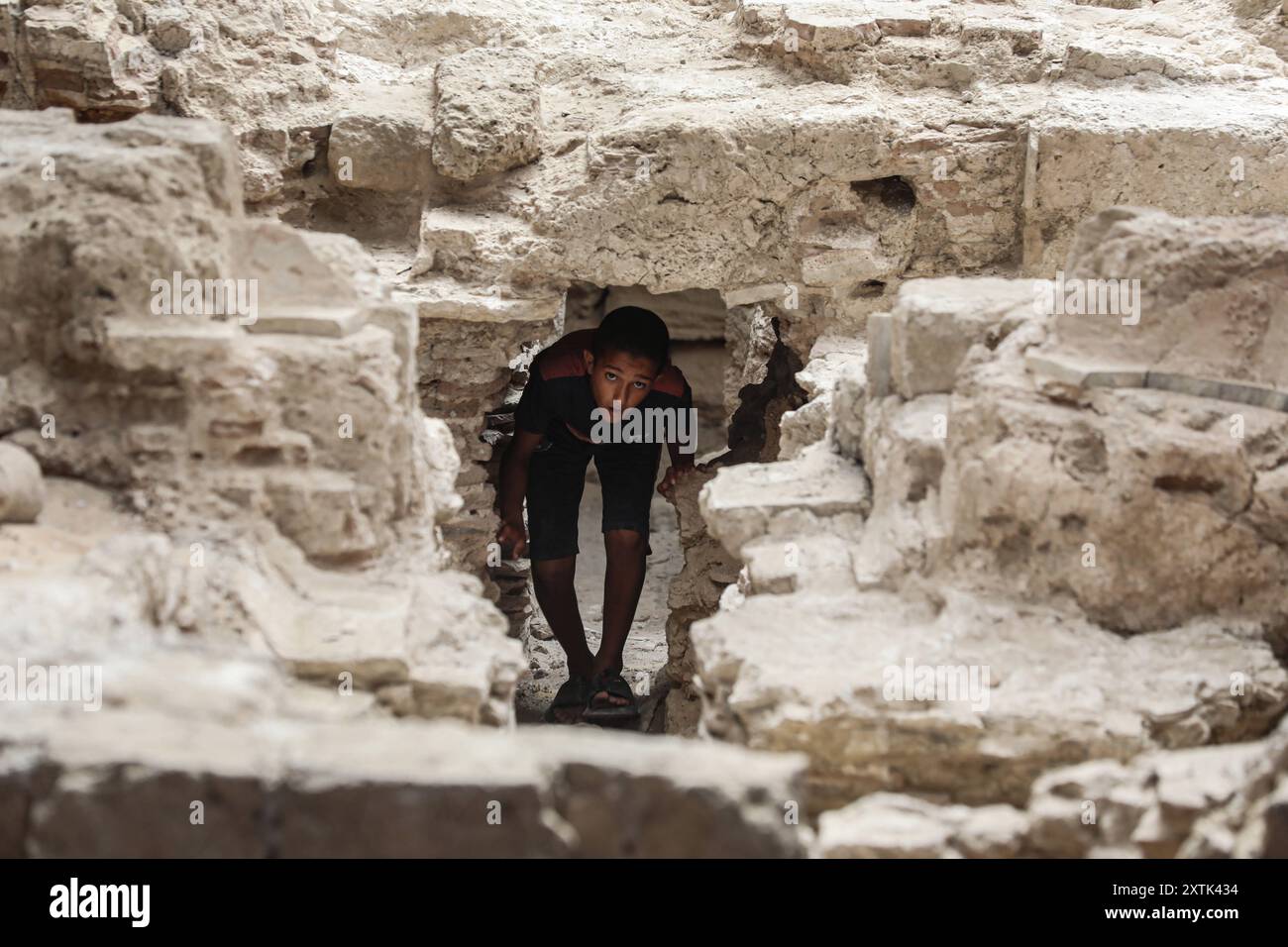 People stand on a platform overlooking ruins at the archaeological site ...