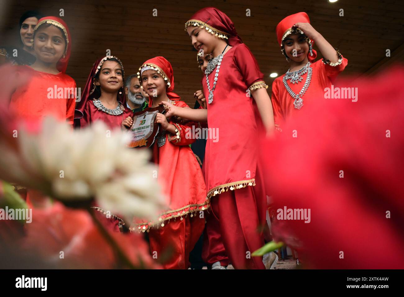 Srinagar, Kashmir, India, on 15 Aug, 2024: Kashmiri schoolgirls in traditional attire, holding ...