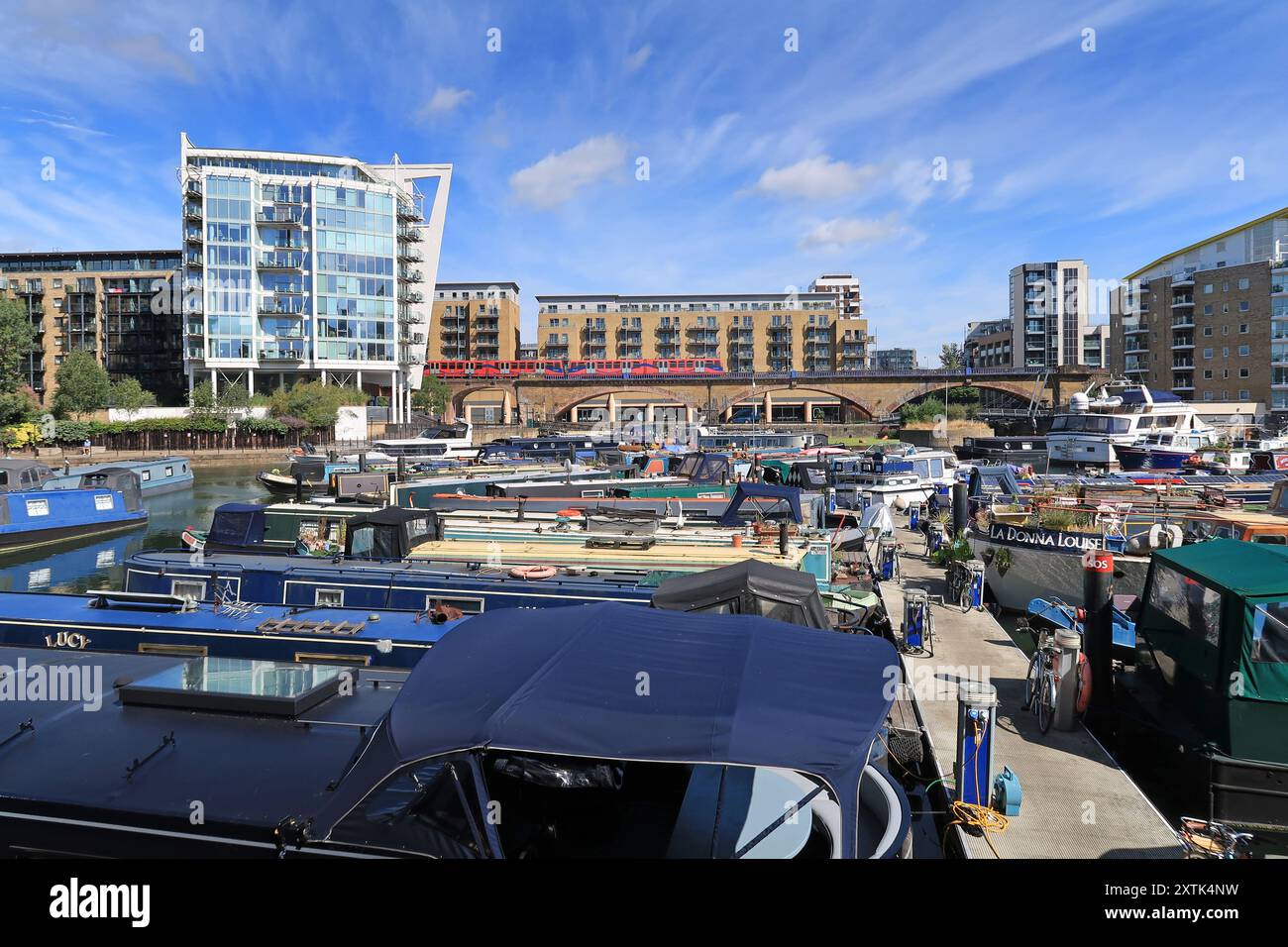 Barges and pleasure boats moored in London's Limehouse Basin, a ...