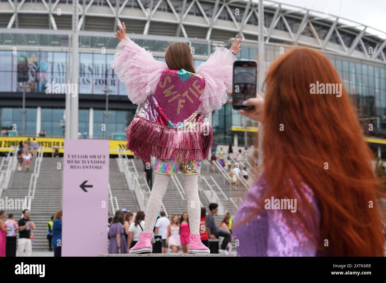 A young fan with a sparkly, decorated jacket reading Swiftie poses for ...
