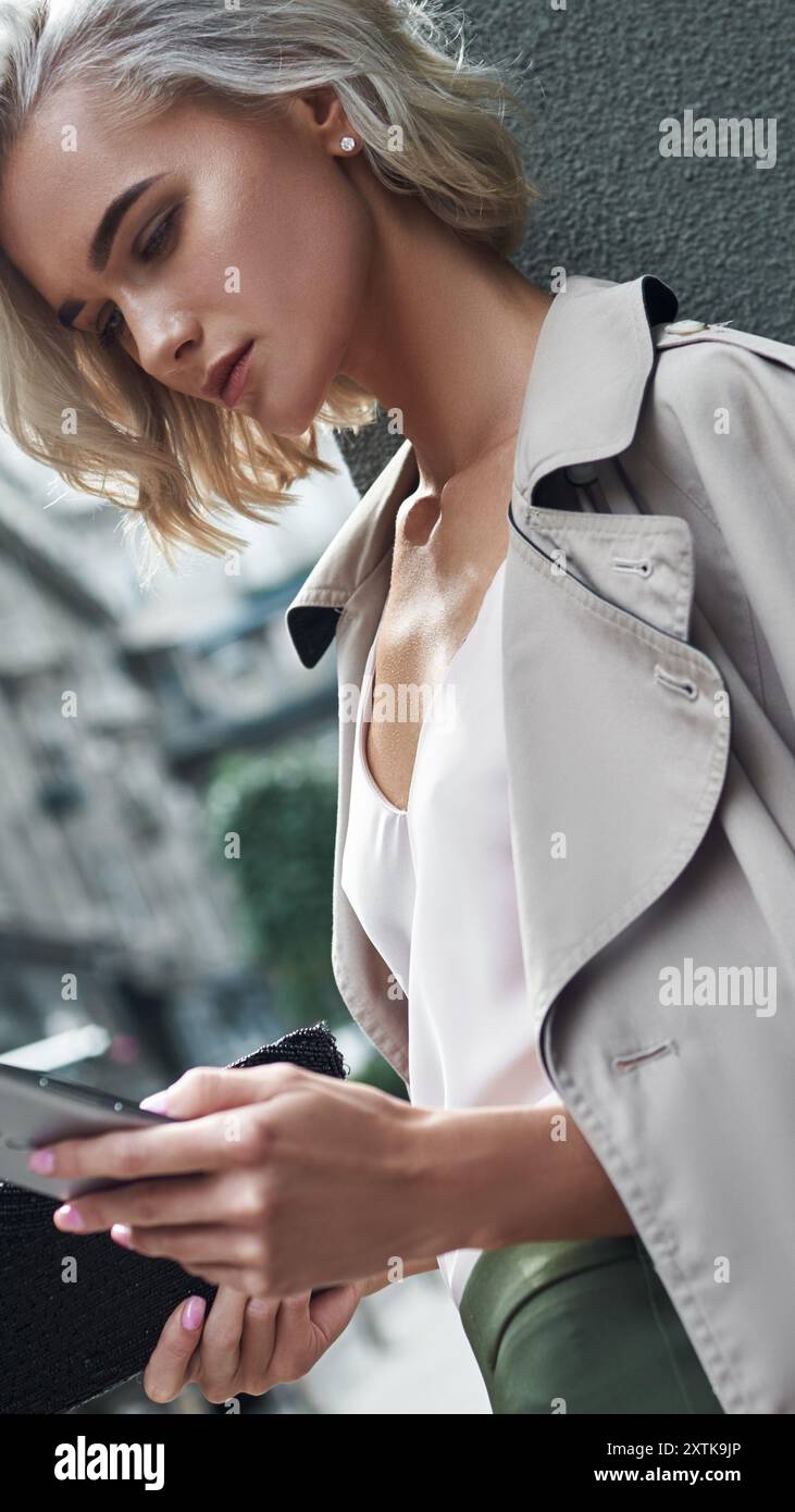 An Urban Fashion Influencer Poses with a Smartphone While Dressed in a ...