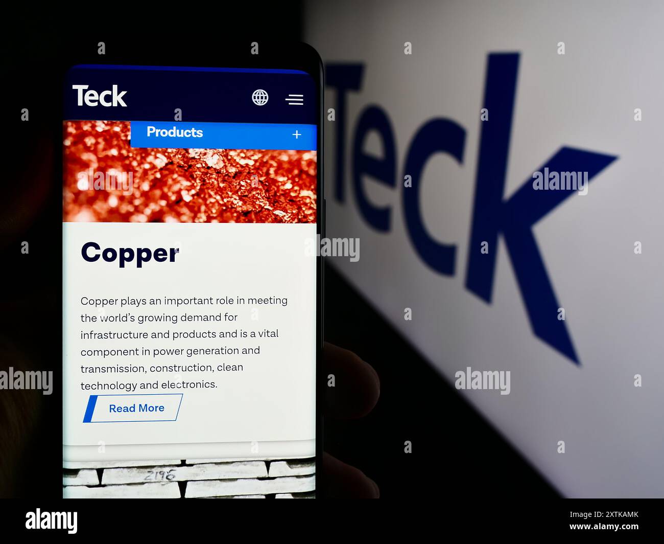 Person holding cellphone with web page of Canadian mining company Teck ...
