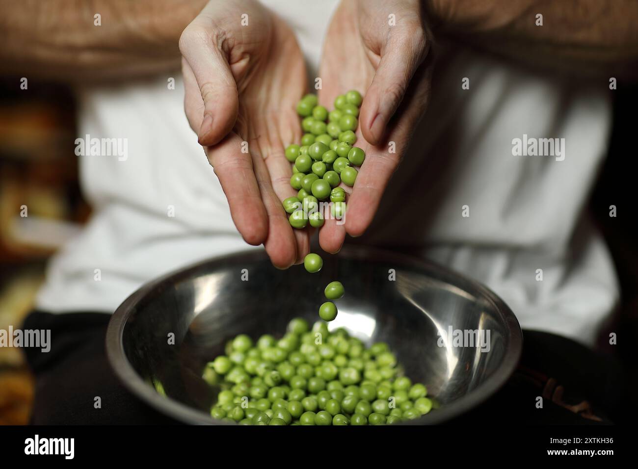 man peeling peas into a bowl Stock Photo - Alamy