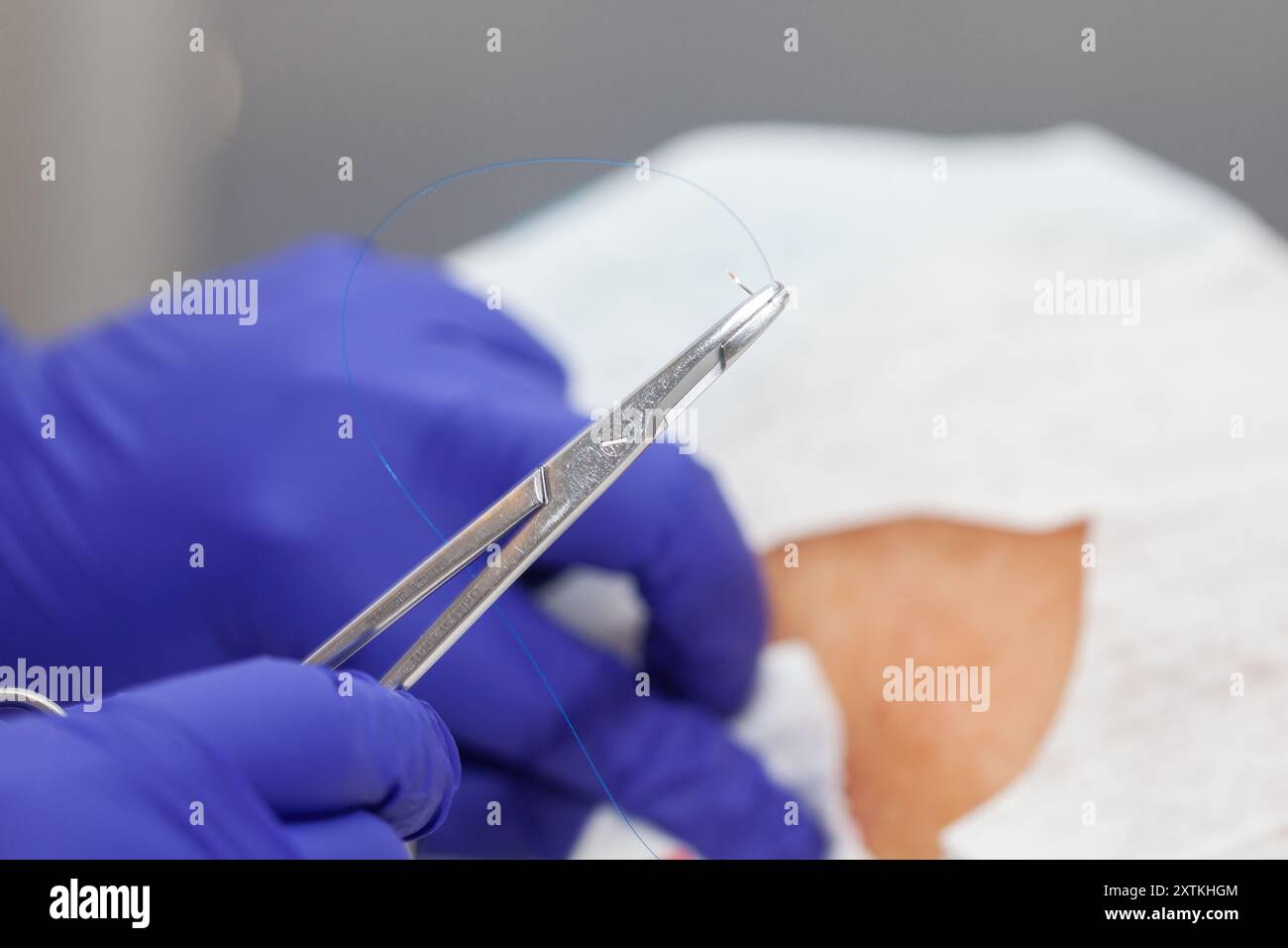 Dermatologist carrying out a skin biopsy on the face of a senior adult ...