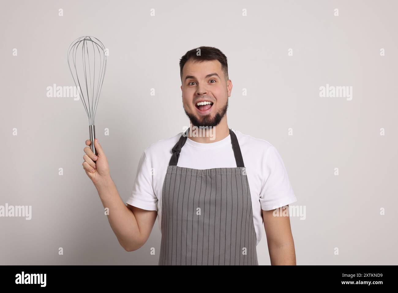 Emotional pastry chef with big whisk on light grey background Stock ...