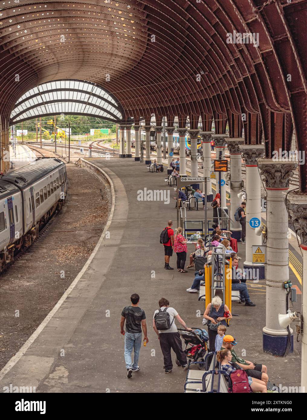 A downward view of railway station platform with passengers waiting for ...