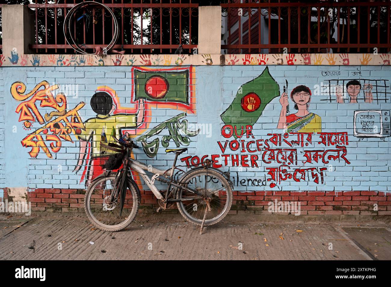 A view of Students paint graffiti on a wall alongside a road to express ...