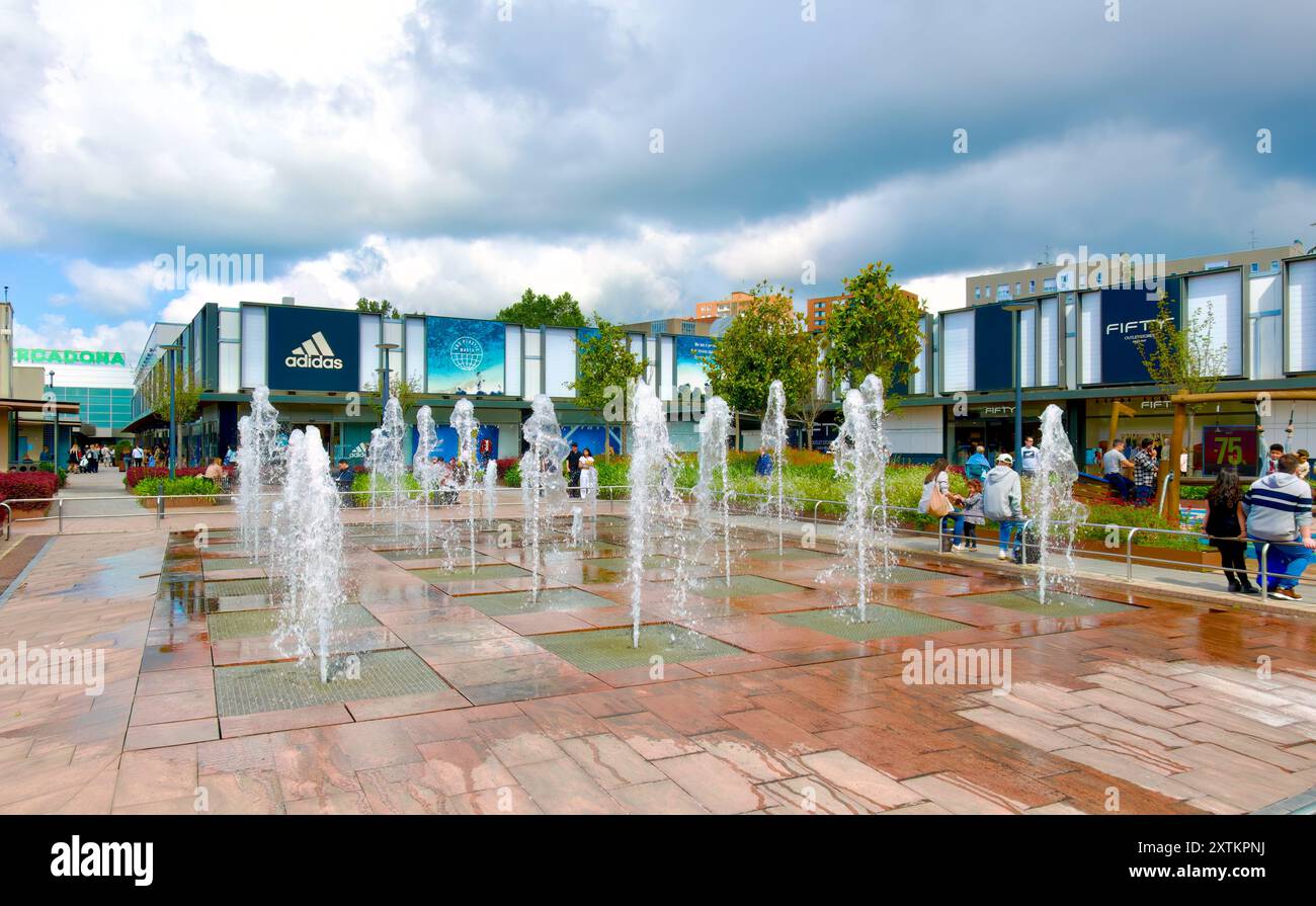 View across an exterior open area with fountains in a grid at the ...