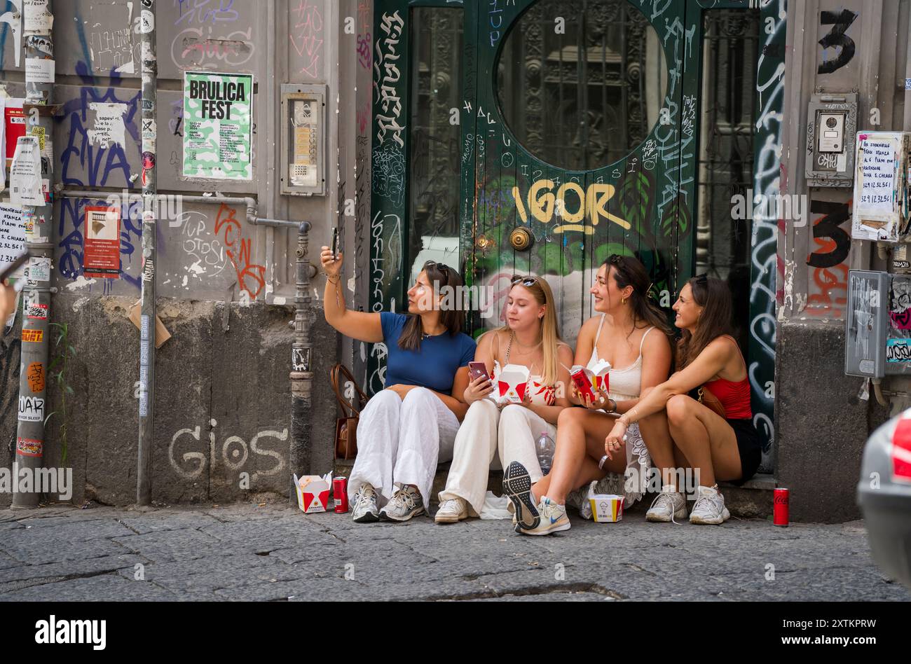 Naples, Italy - June 22, 2024: A cheerful group of four women sit ...