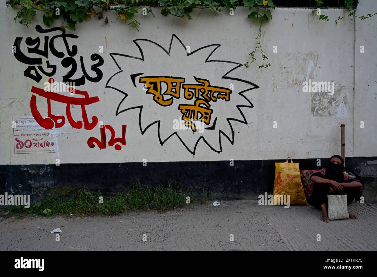 People are walking past a graffiti wall while students are painting ...