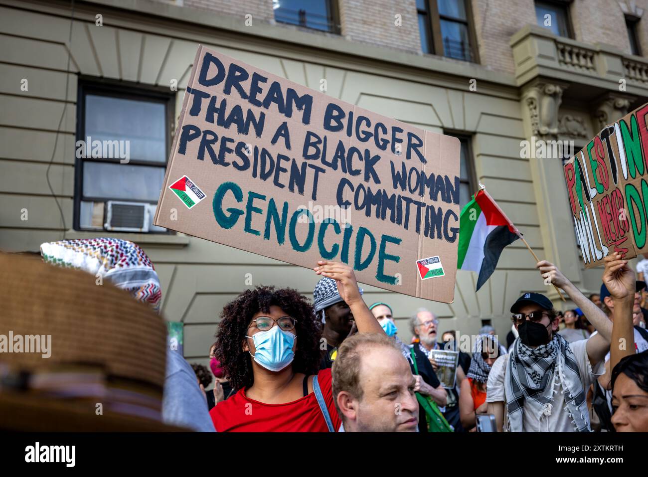 A person holds a sign that reads "Dream bigger than a black women ...