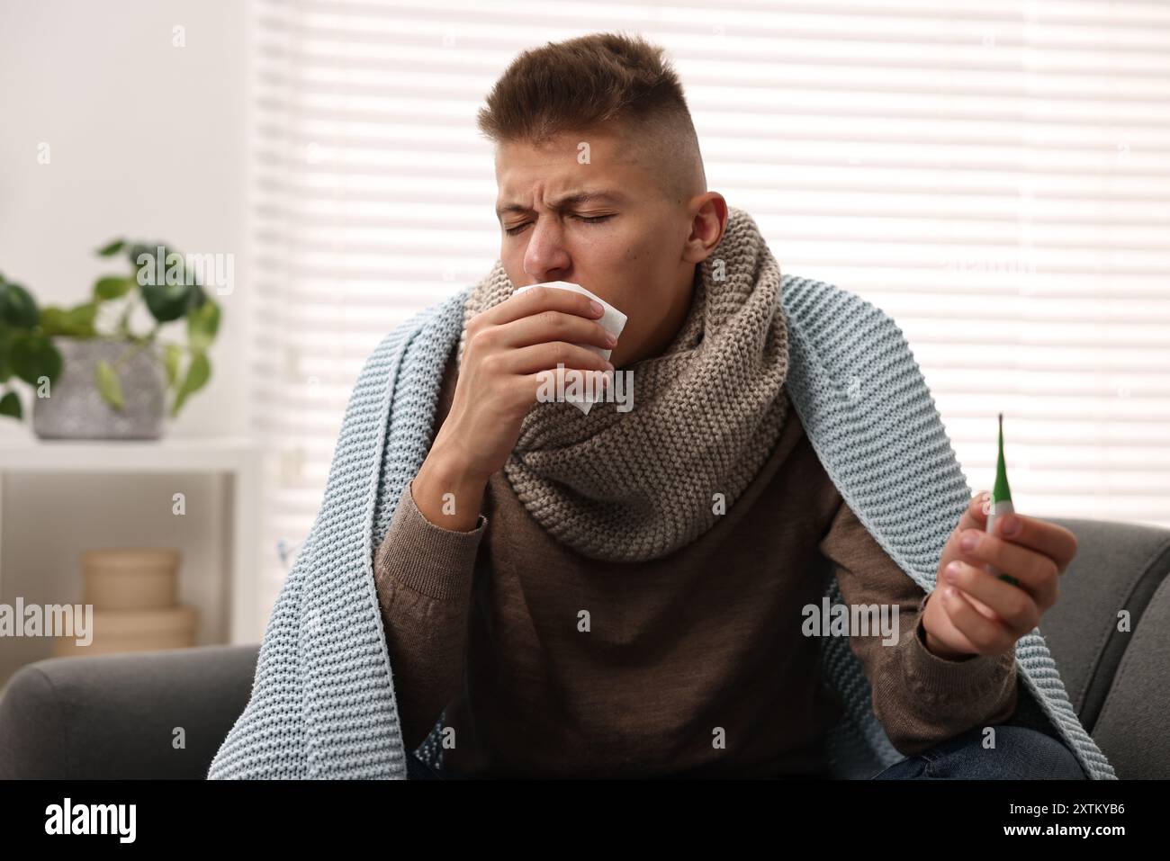 Cold symptom. Young man suffering from fever at home Stock Photo - Alamy