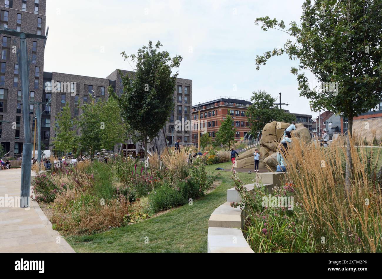 People sitting and children playing in Pounds park in Sheffield city ...