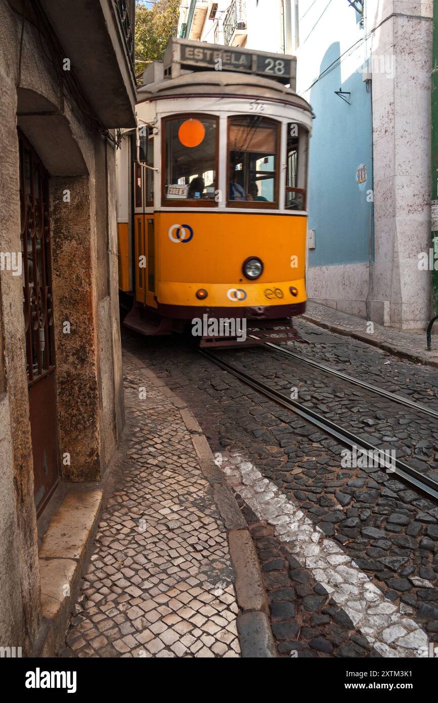The classic 28 yellow tram in the historic district of Lisbon in ...