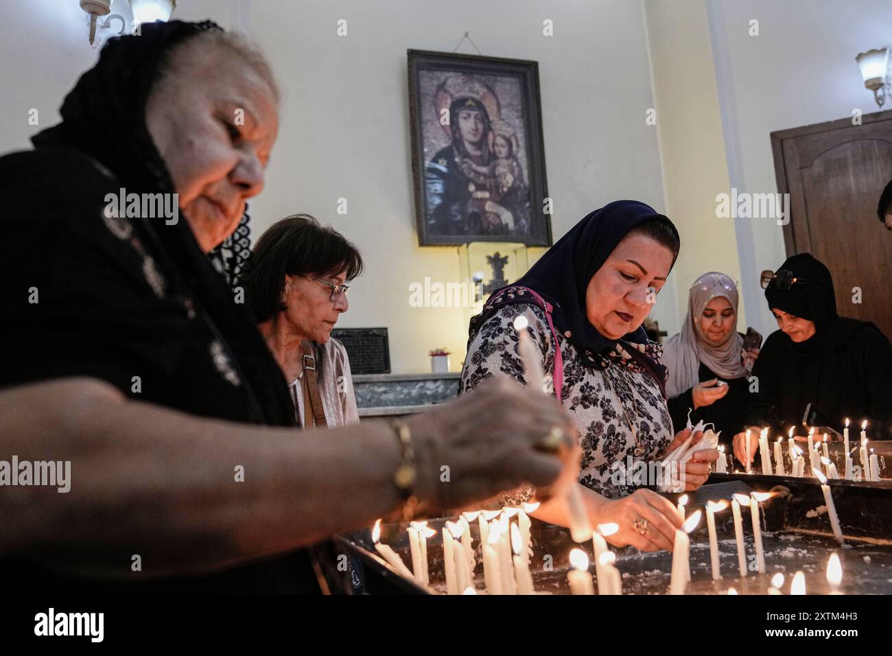 Iraqi Catholic believers light candles during the feast day of the ...