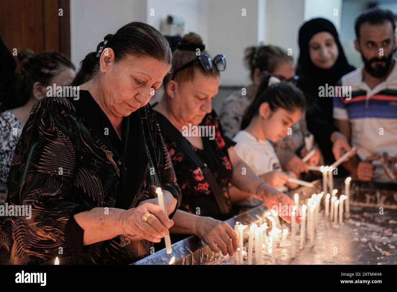 Iraqi Catholic believers light candles during the feast day of the ...