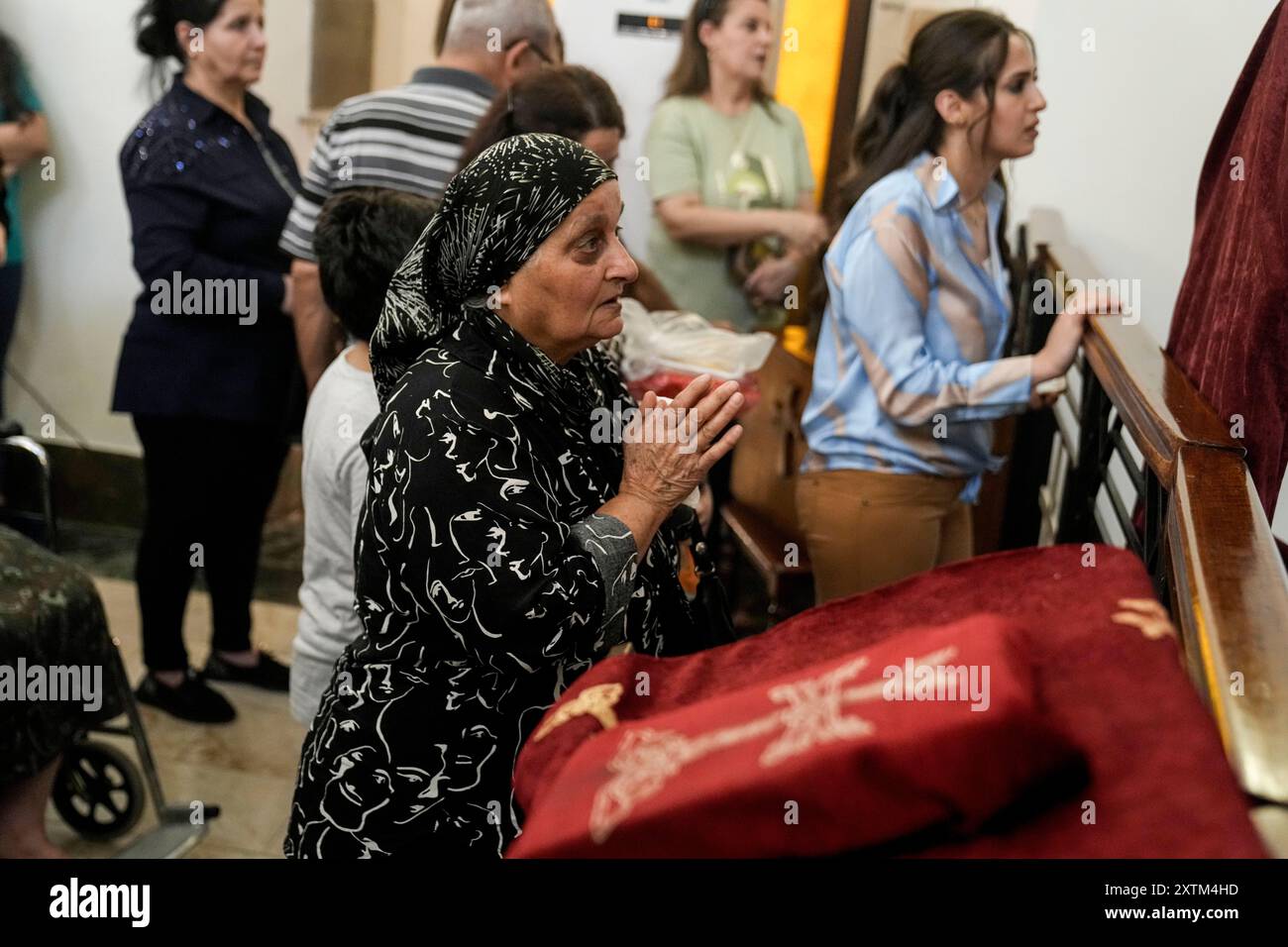 Iraqi Catholics pray during the feast day of the Assumption of Virgin ...