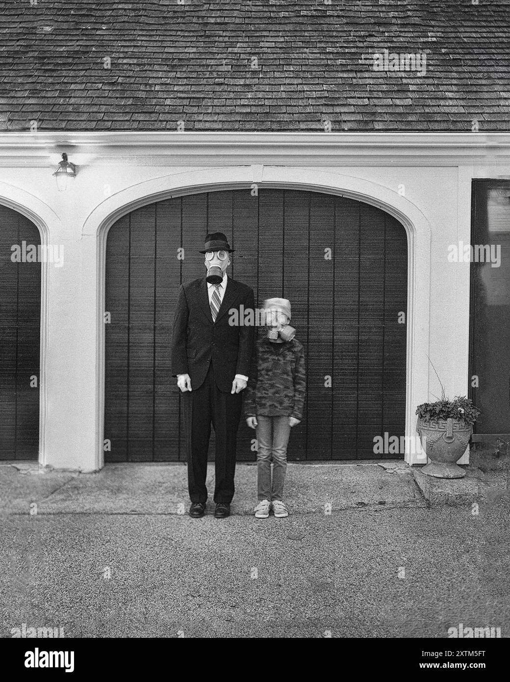 Full-length portrait of mid-adult businessman and teen boy wearing gas ...