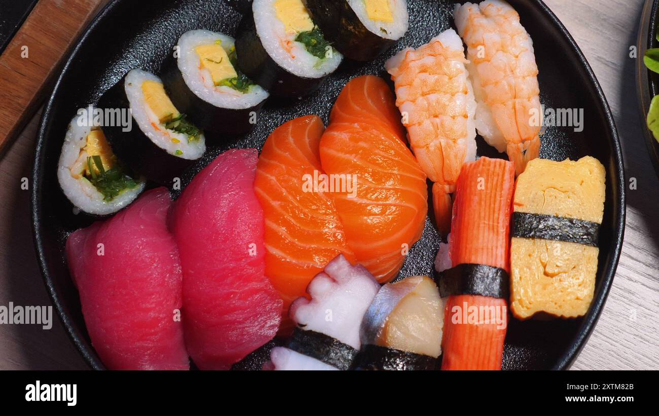 Assorted sushi platter with various types of nigiri, maki rolls, and ...