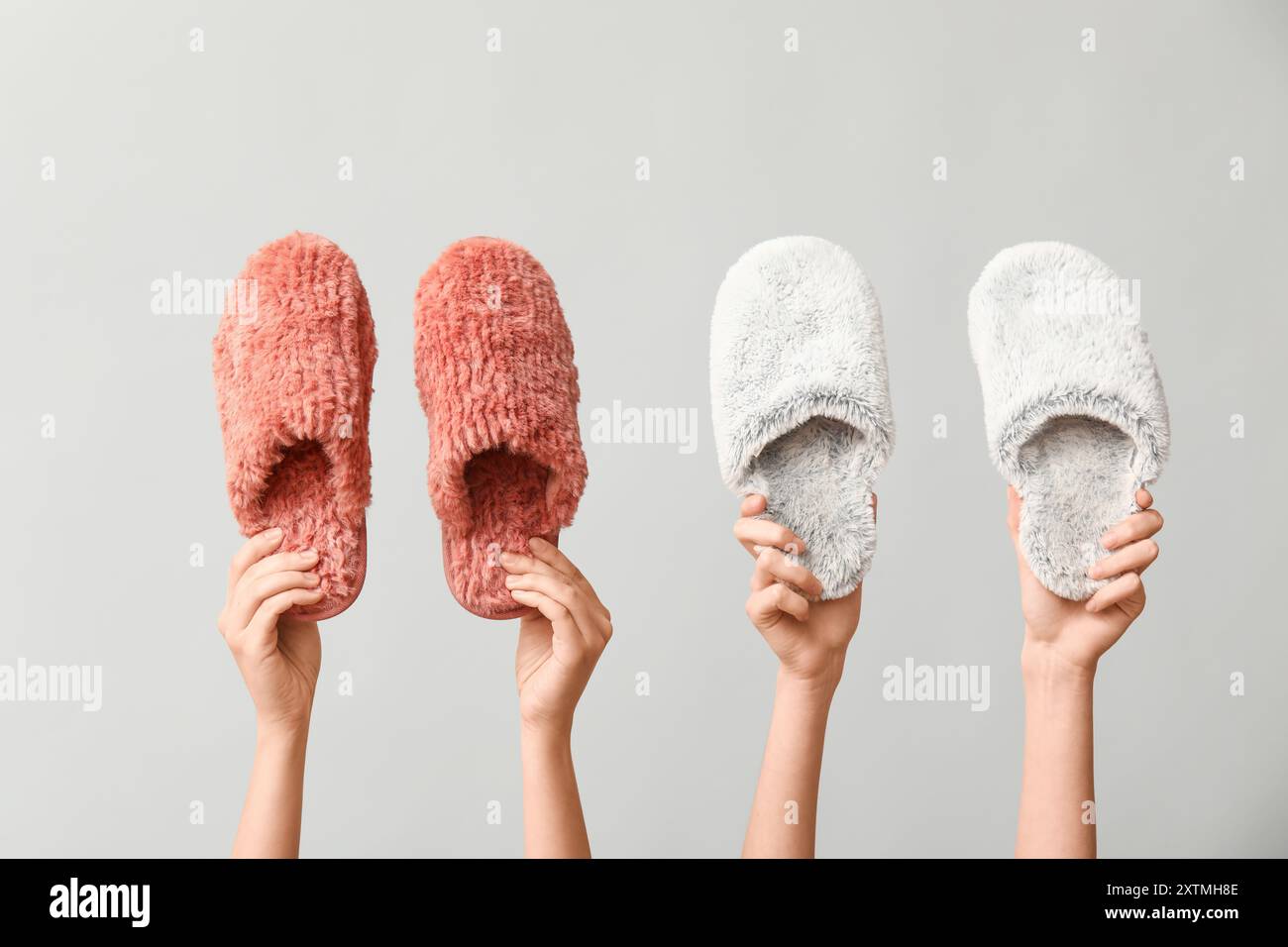 Female hands holding slippers on white background Stock Photo - Alamy