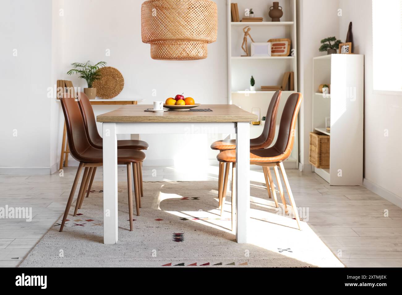 Interior of light room with dining table and shelf units Stock Photo ...