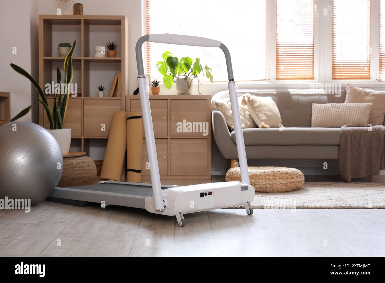 Modern treadmill in interior of cozy living room Stock Photo - Alamy