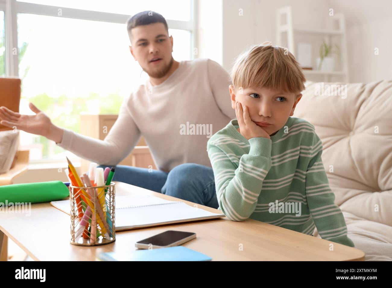 Cute boy taking offense while his father arguing at home Stock Photo ...