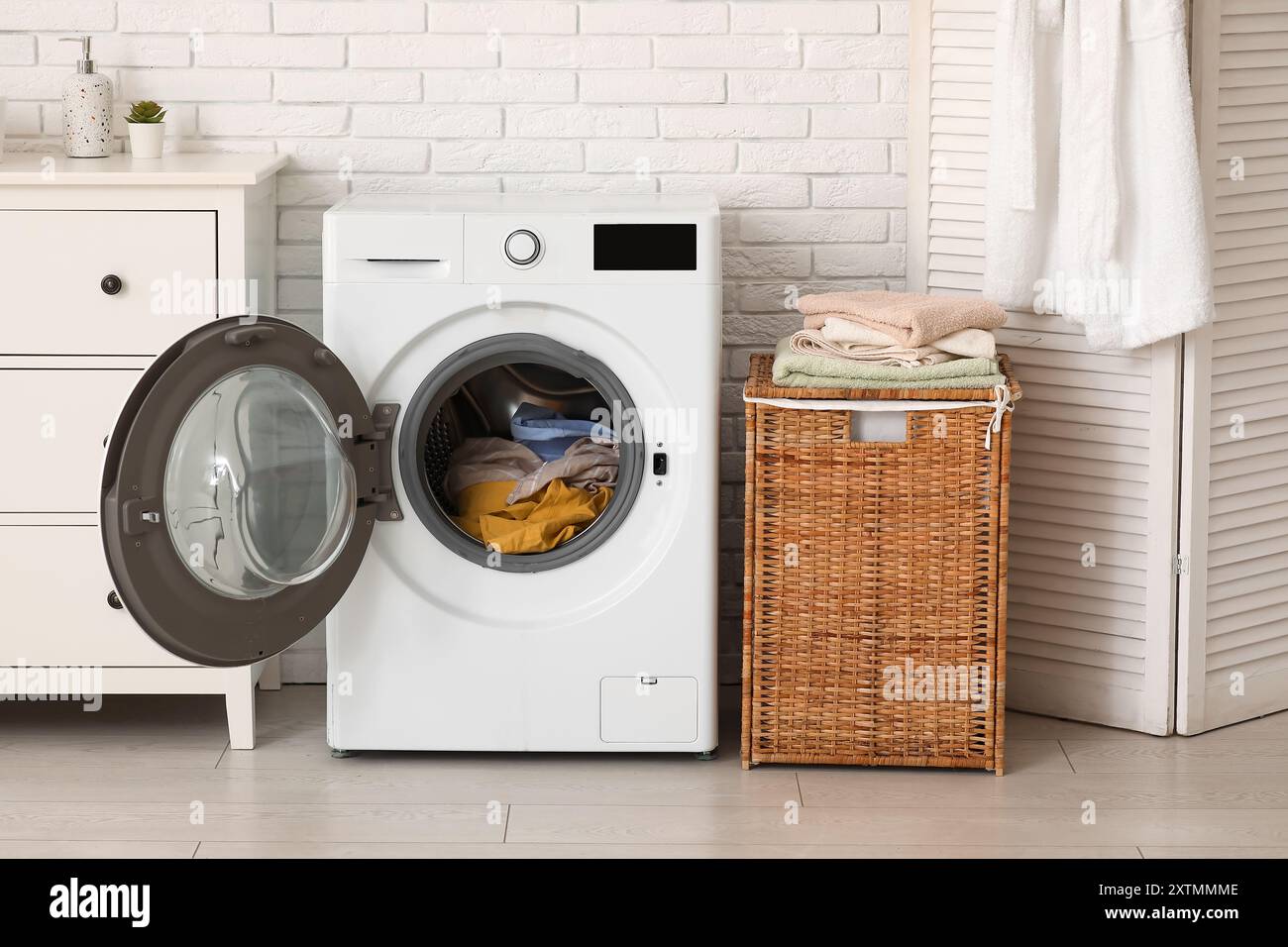 Modern washing machine with dirty clothes in laundry room Stock Photo ...