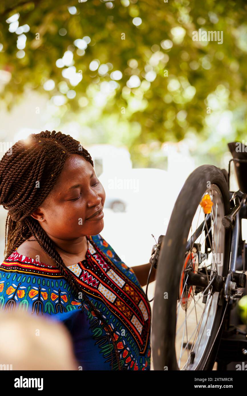 Skillful active black woman performing maintenance on bicycle ...
