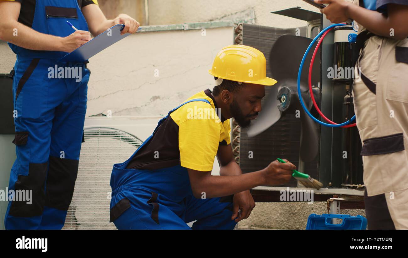Experienced workers tasked with yearly condenser cleaning, using ...