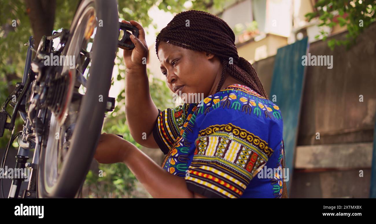 Sportloving african american female checking and securing bicycle wheel ...