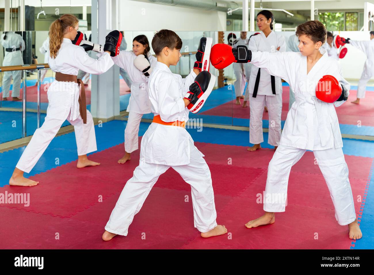 Trainier teaching girl jabbing during karate training Stock Photo - Alamy