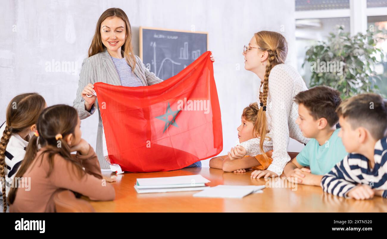 Teacher showing Morocco flag to group of schoolchildren Stock Photo - Alamy