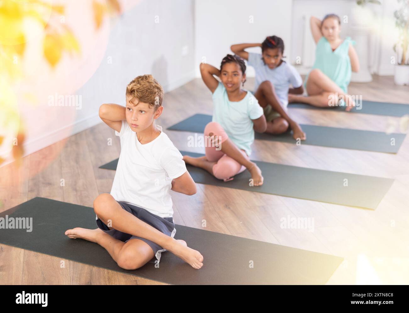 Group of multiethnic children doing yoga in studio Stock Photo - Alamy