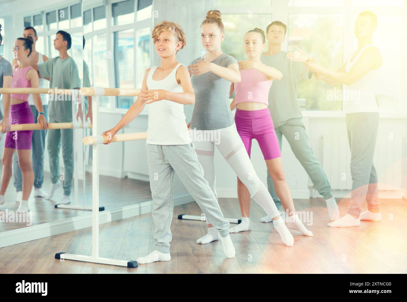 Teacher conducts class with teen girls and boys in ballet studio ...