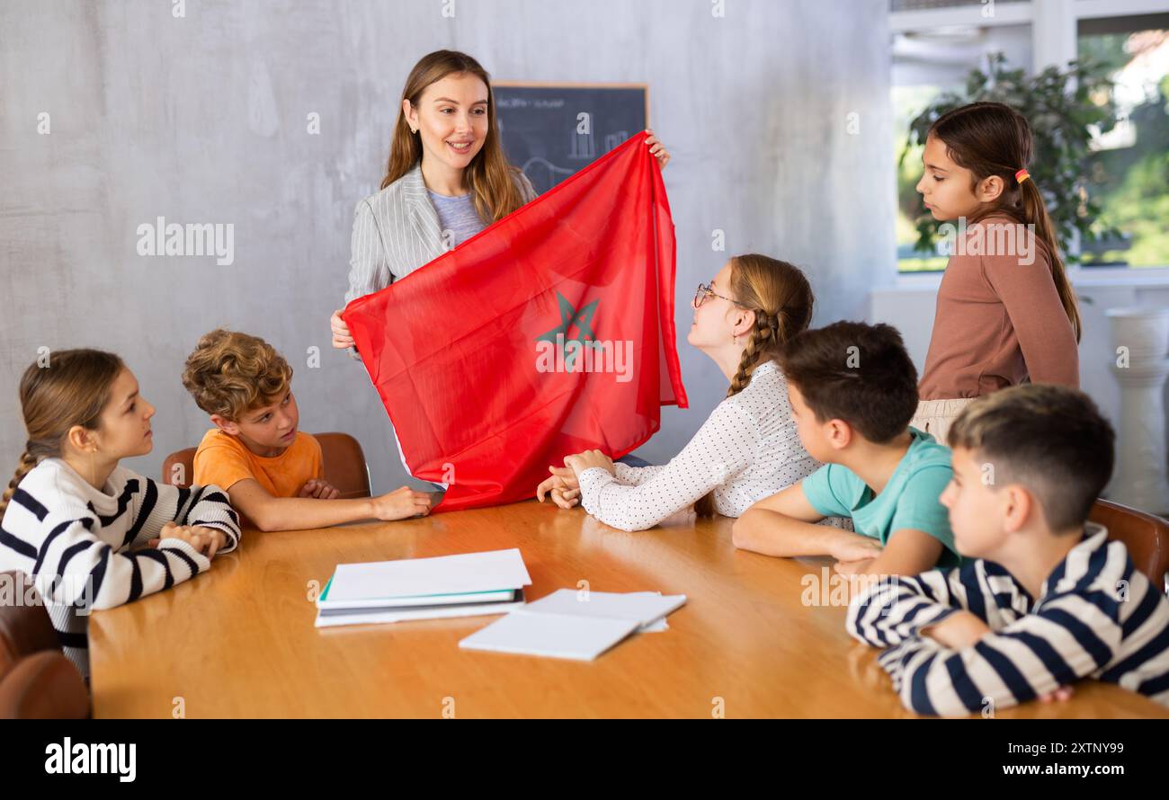 Teacher showing Morocco flag to group of schoolchildren Stock Photo - Alamy