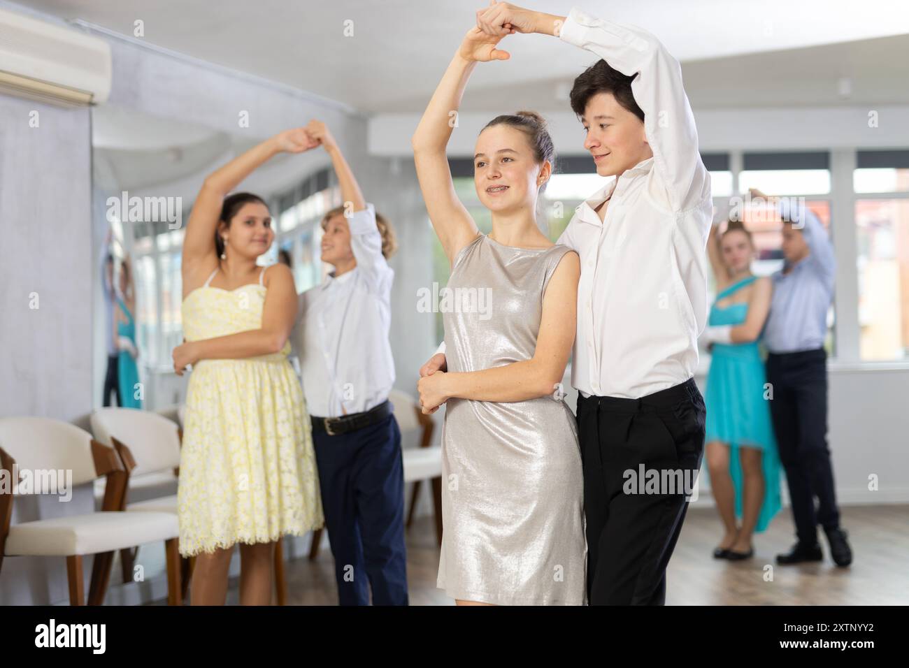 Enthusiastic teenagers performing waltz during group dance lesson Stock ...