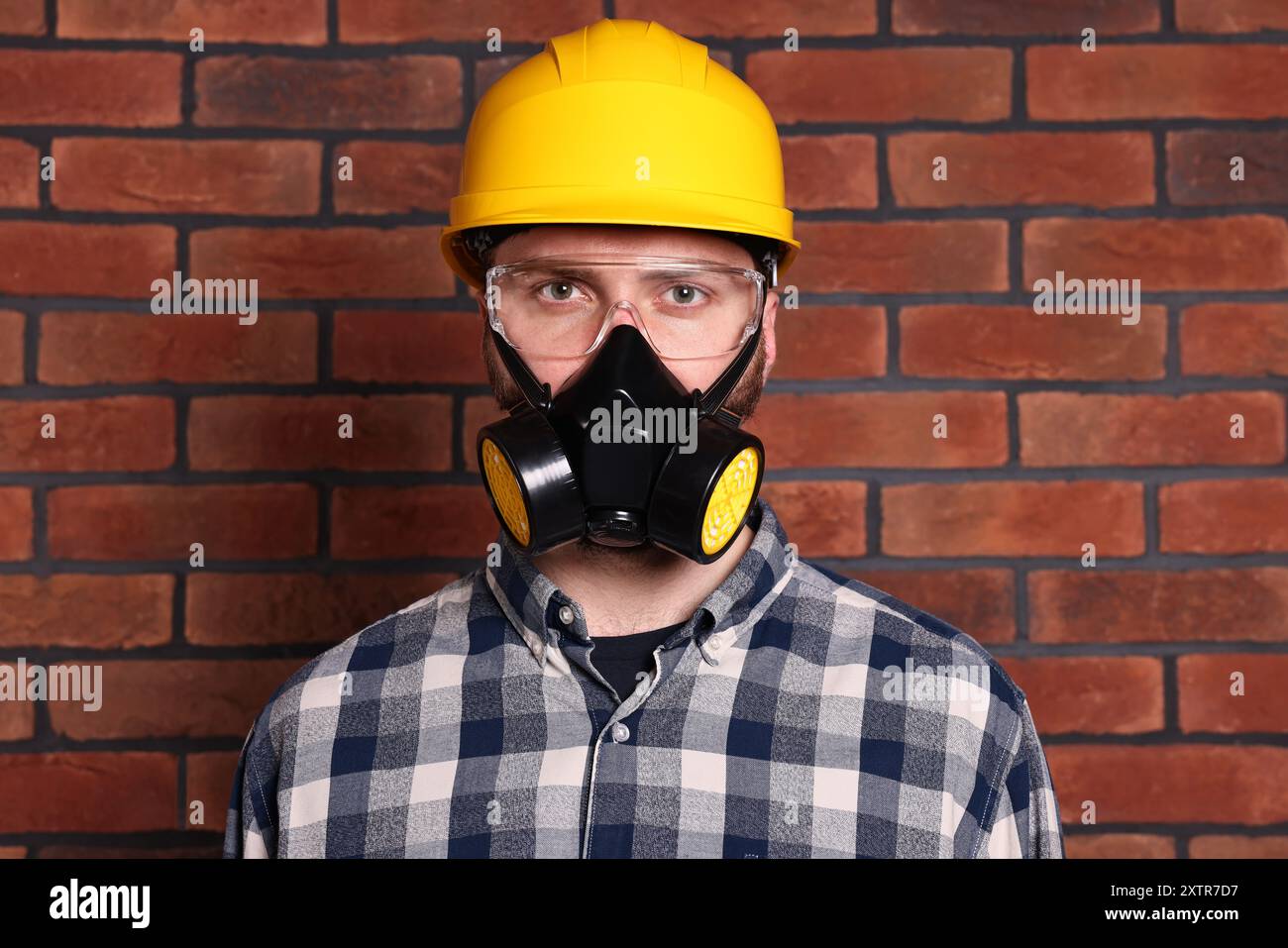 Man in respirator mask and hard hat near red brick wall Stock Photo - Alamy
