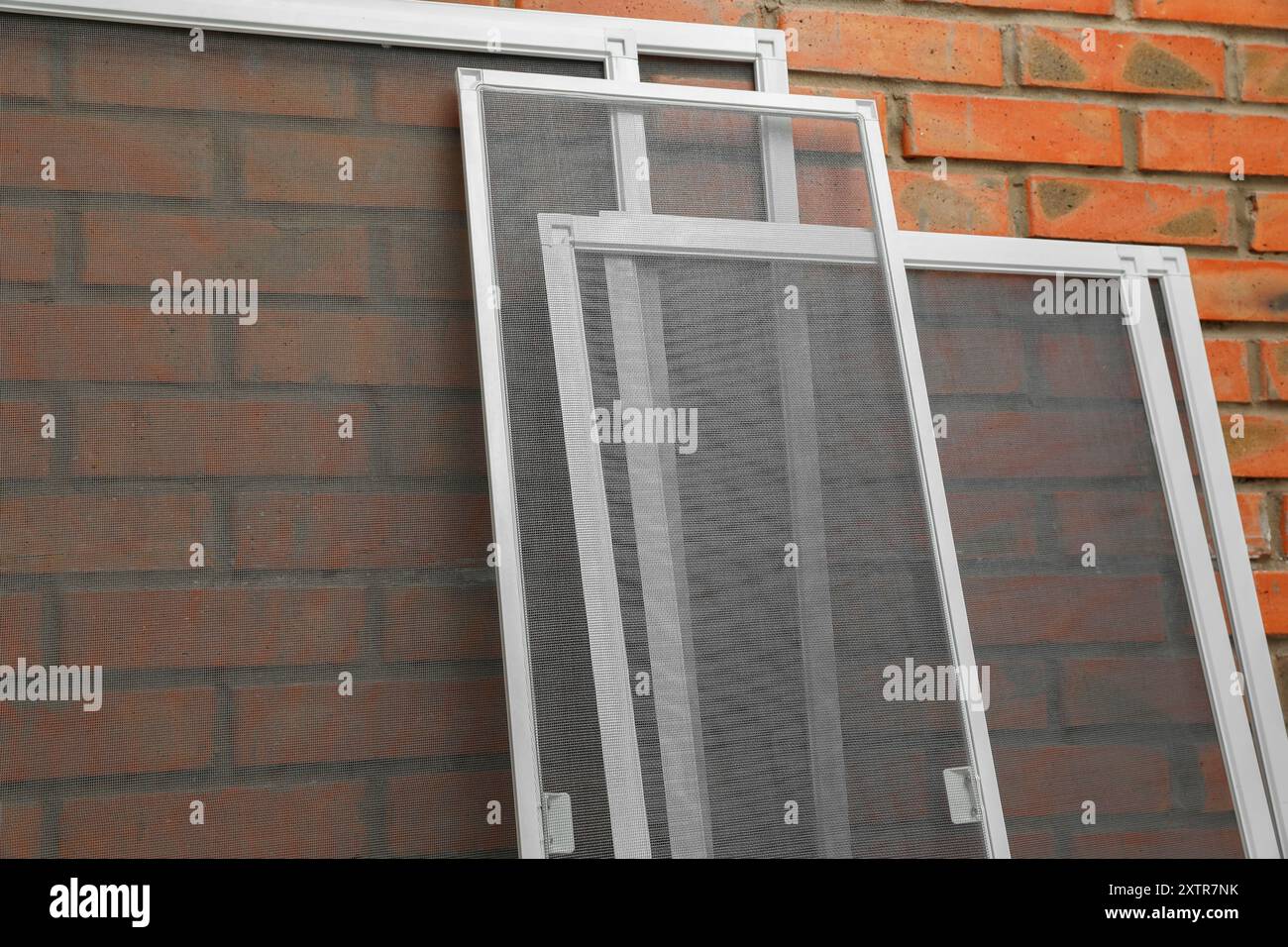 Set of window screens near brick wall Stock Photo - Alamy