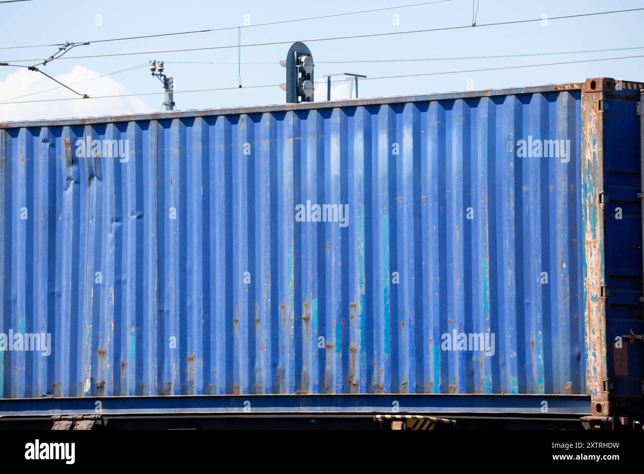 This image captures a blue shipping container loaded on a train ...